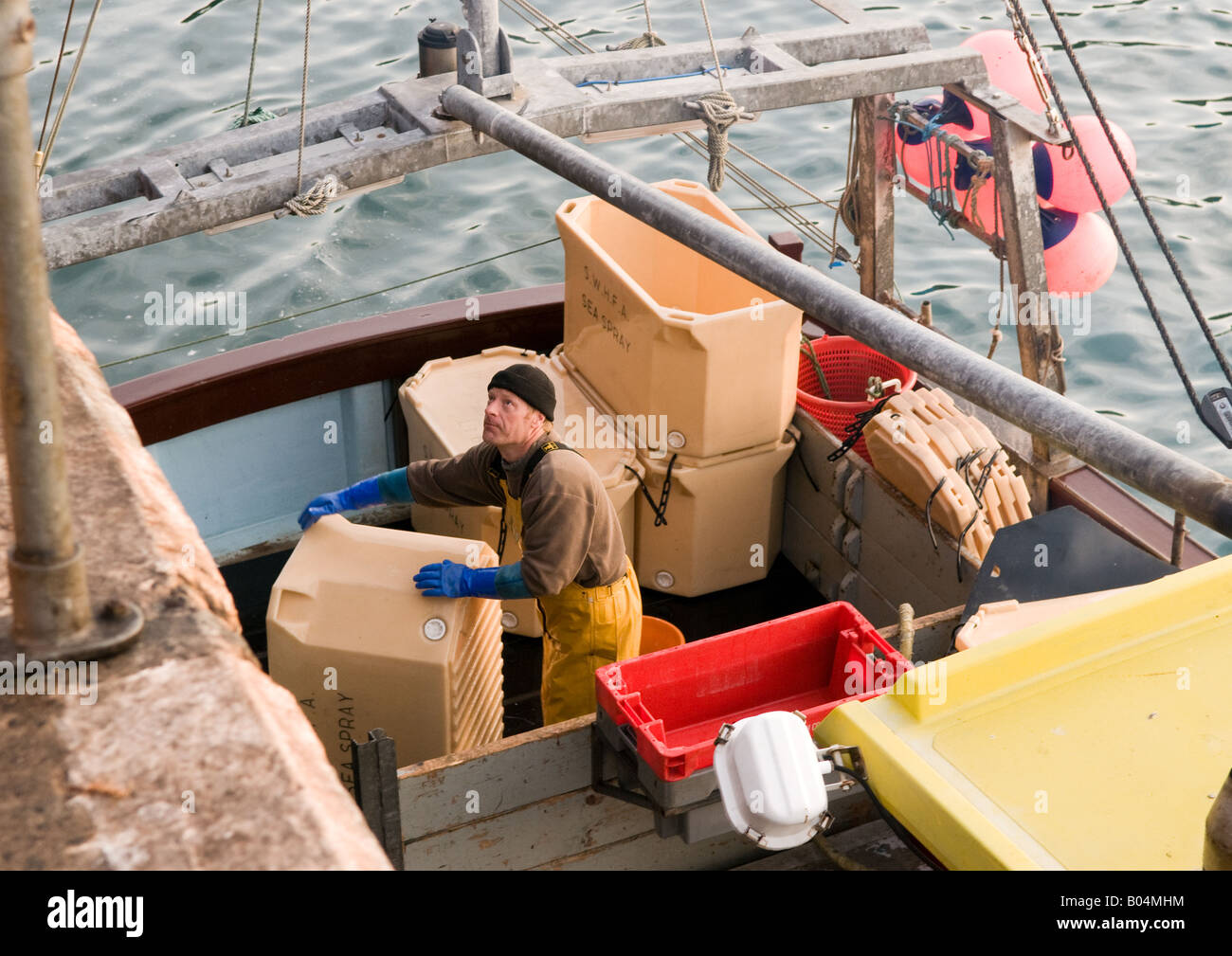 Fisherman loading empty ice boxes onto fishing boat for storing caught ...