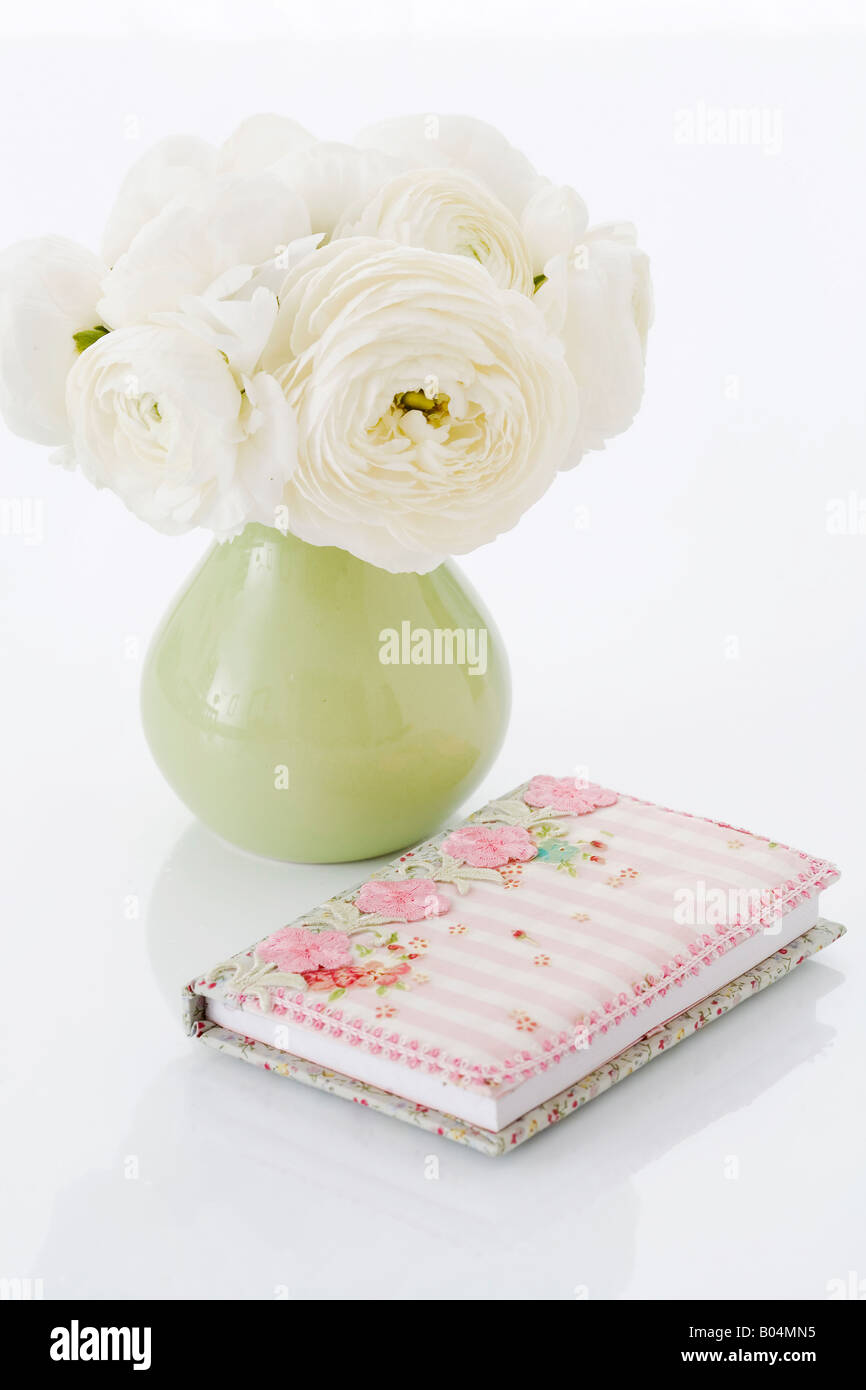Journal and a vase with flowers Stock Photo - Alamy
