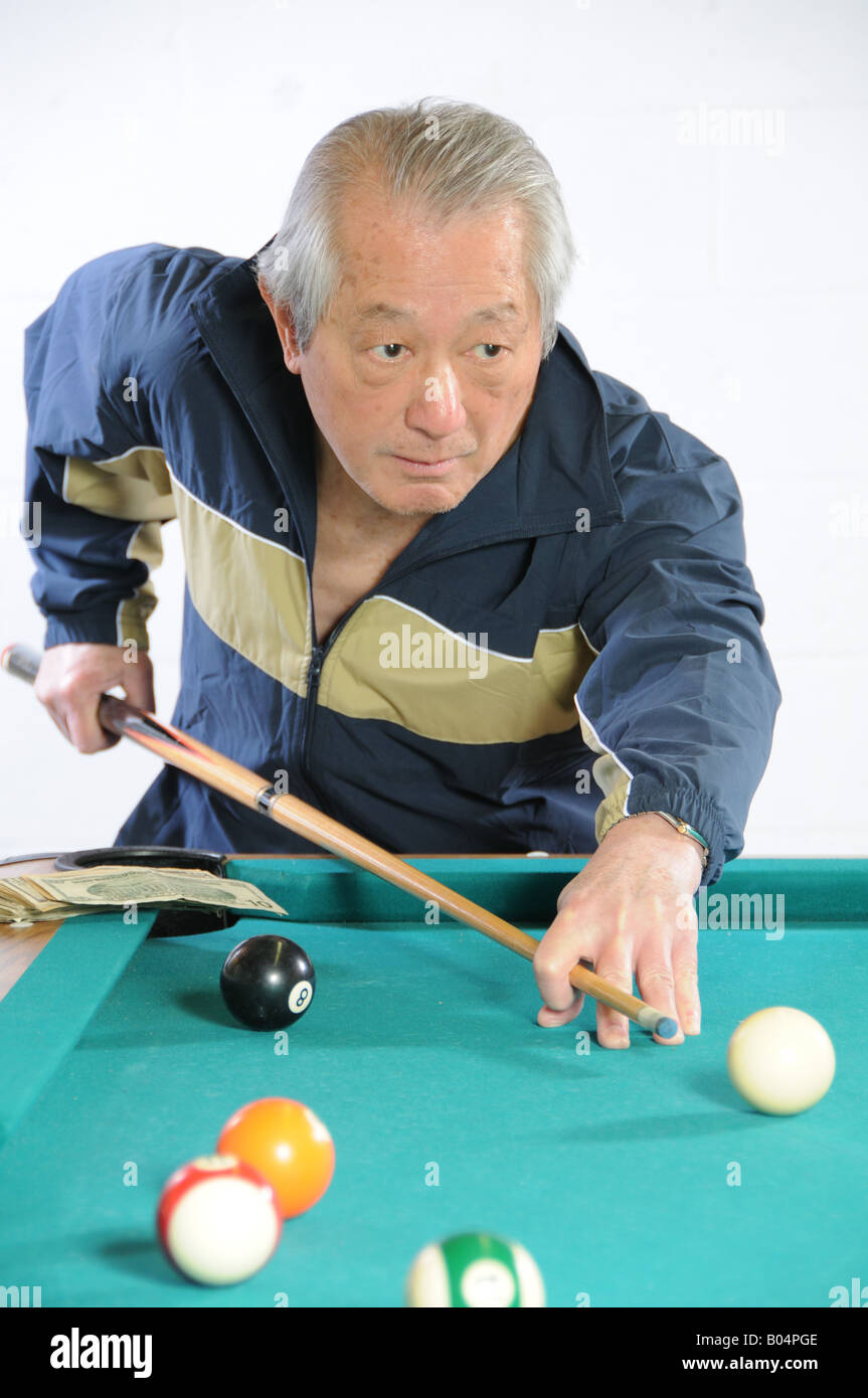senior asian man gamble playing a game of eight ball Stock Photo - Alamy