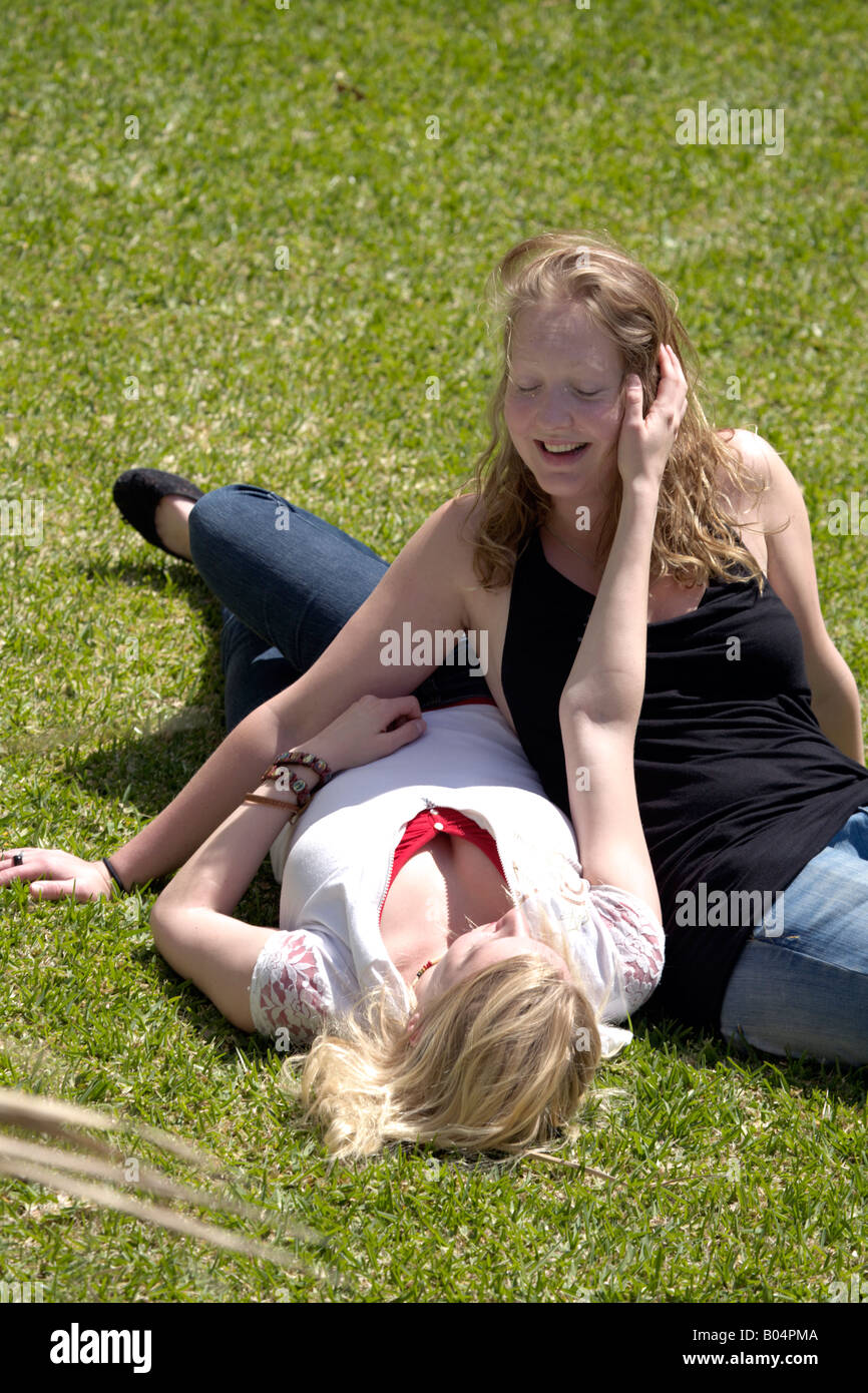 Two young women frolicking intimately on the grass, Costa del Sol ...