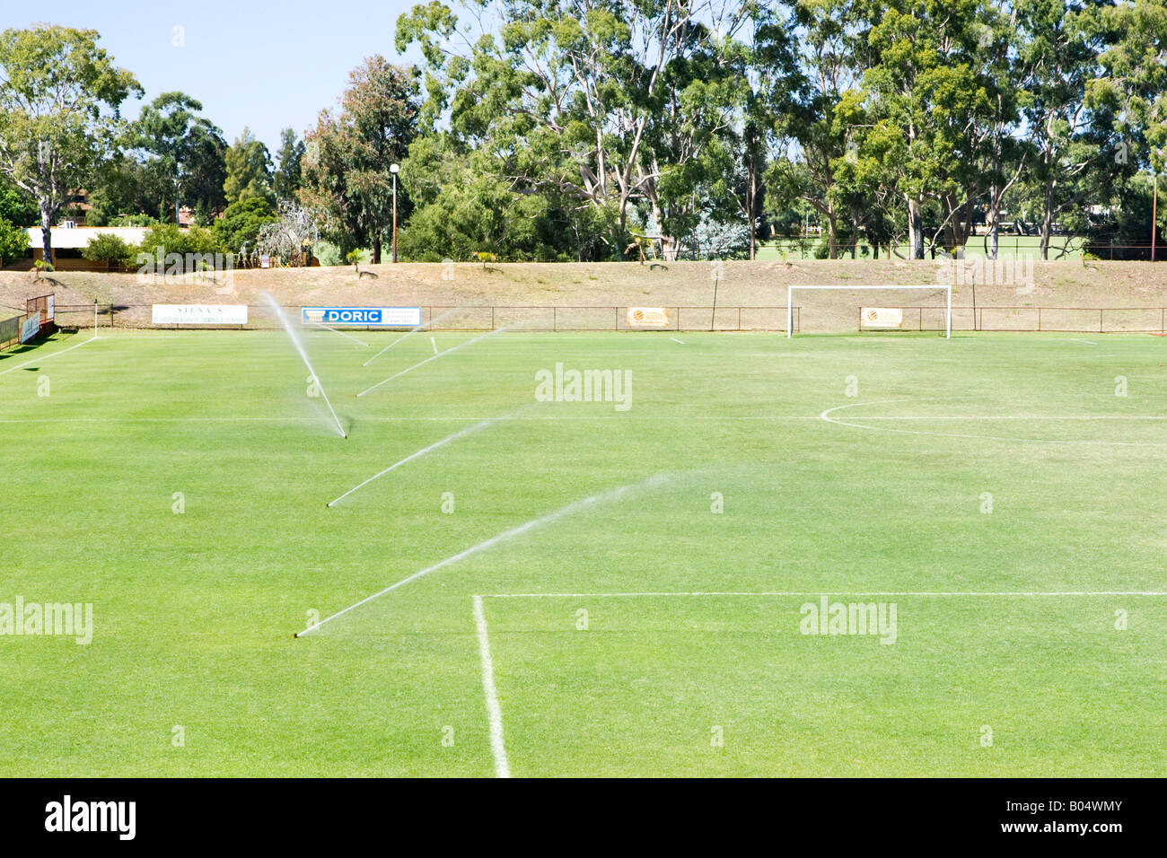Six irrigation sprinklers watering a football pitch at Litis Stadium in ...
