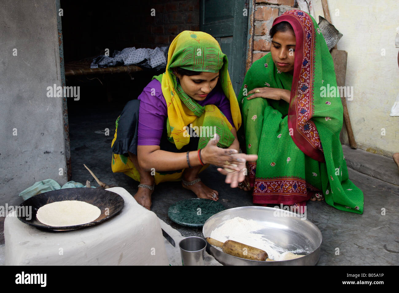 Women preparing chapati in village home near Agra, Uttar Pradesh, India ...