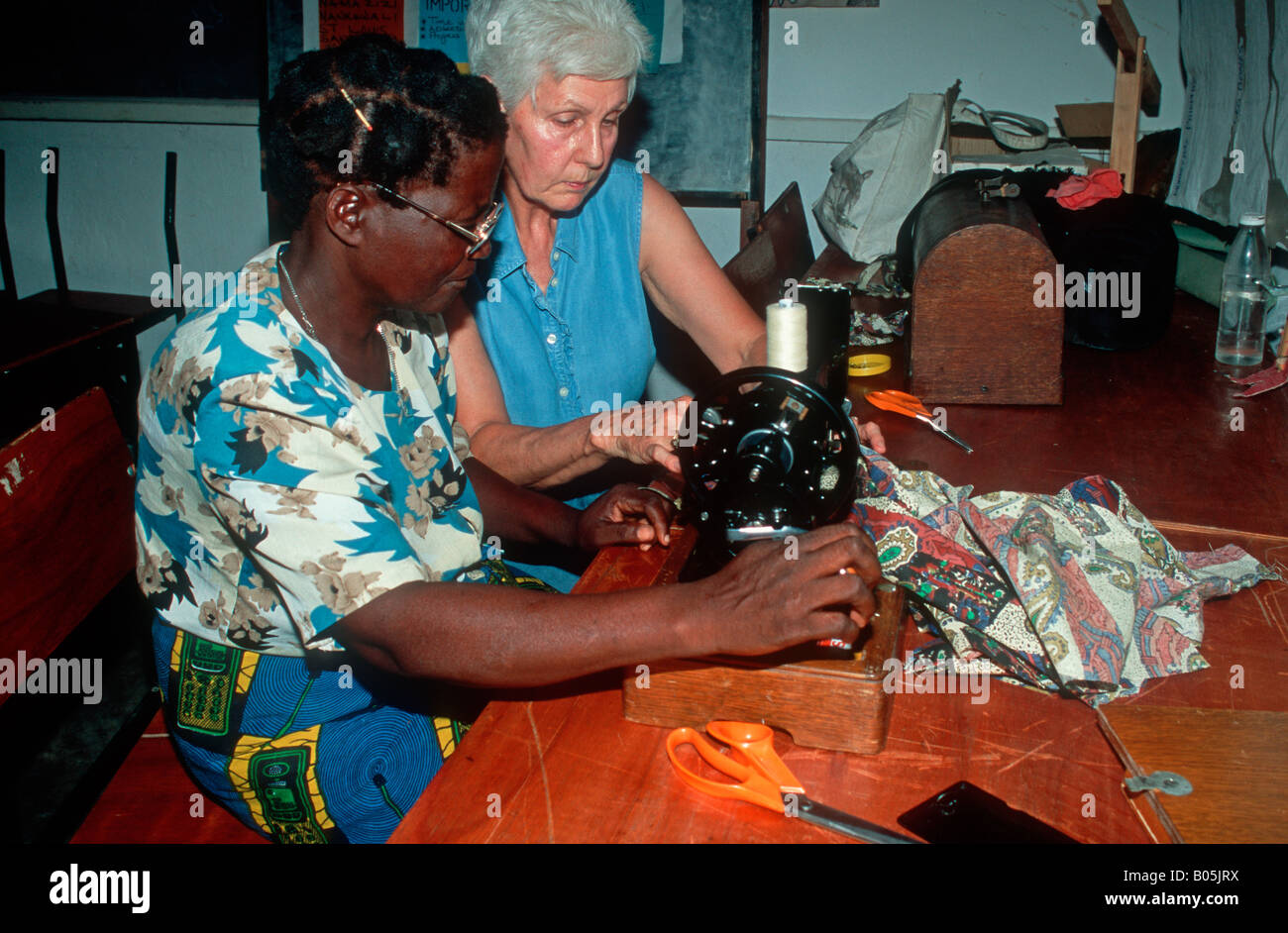 Woman aid worker teaching African woman to use sewing machine WURCS ...