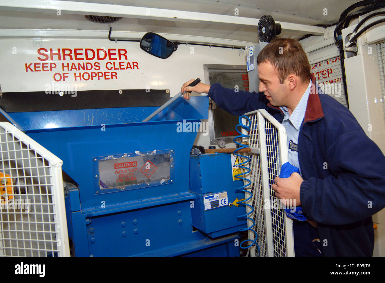 A man operates a mobile paper shredder on a lorry which collects ...