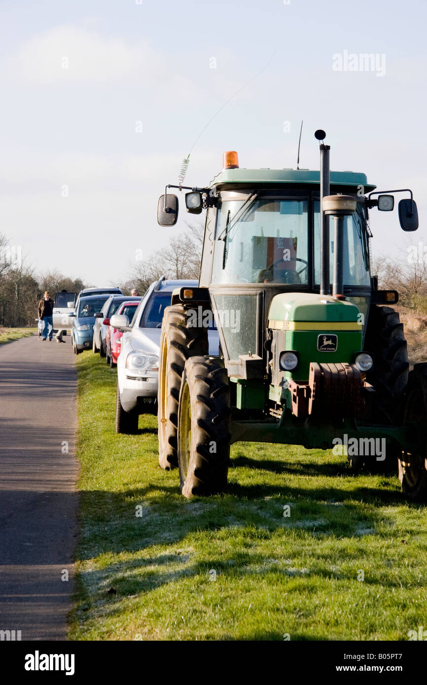 Tractor and a line of parked cars Stock Photo - Alamy