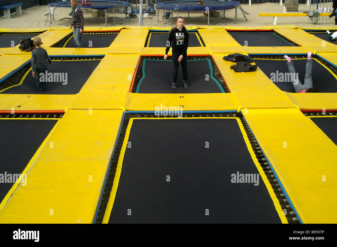 Kids children jumping happy on yellow trampoline outdoors in ...