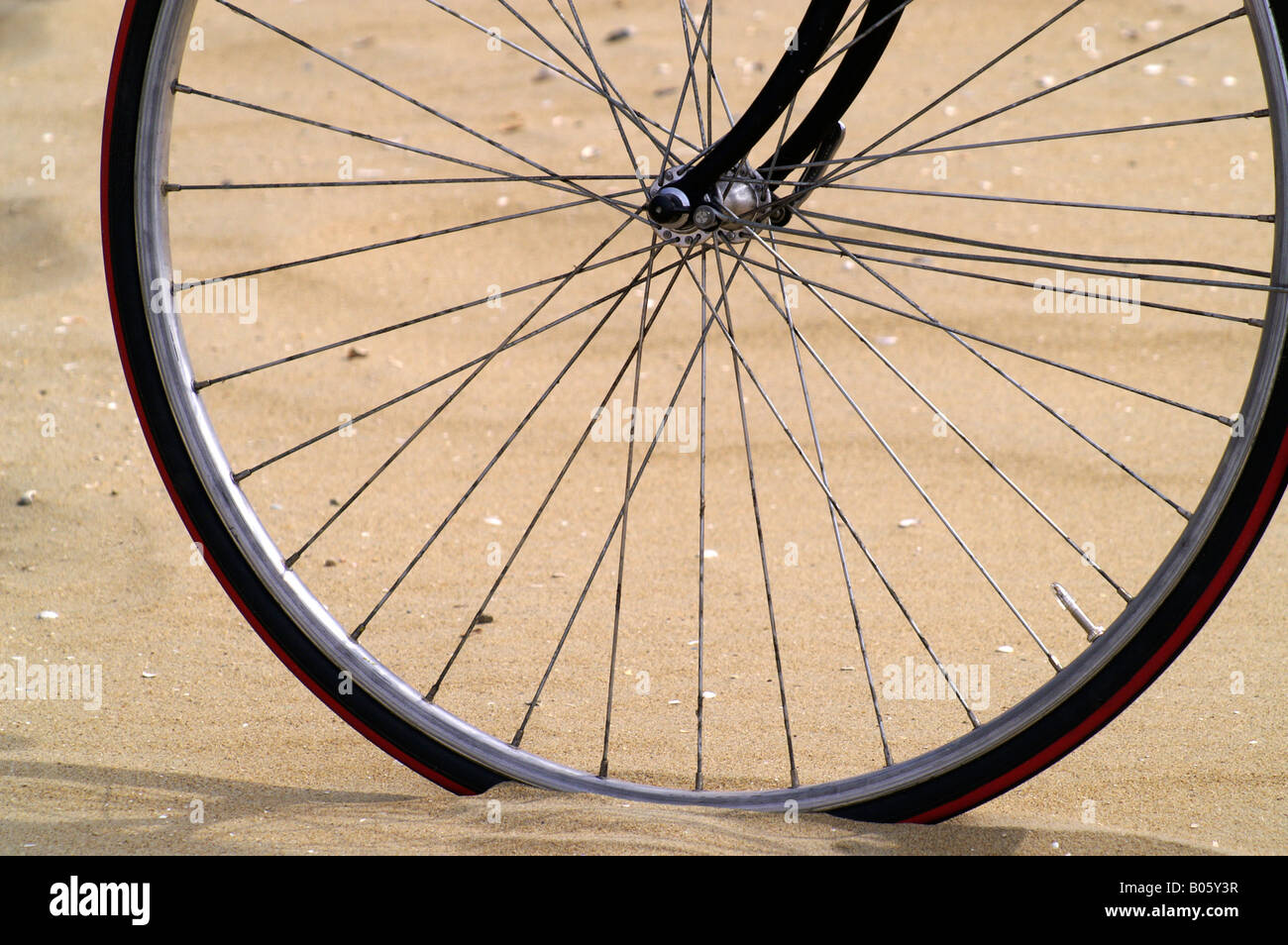 Front wheel of bicycle buried in sand on beach Stock Photo - Alamy
