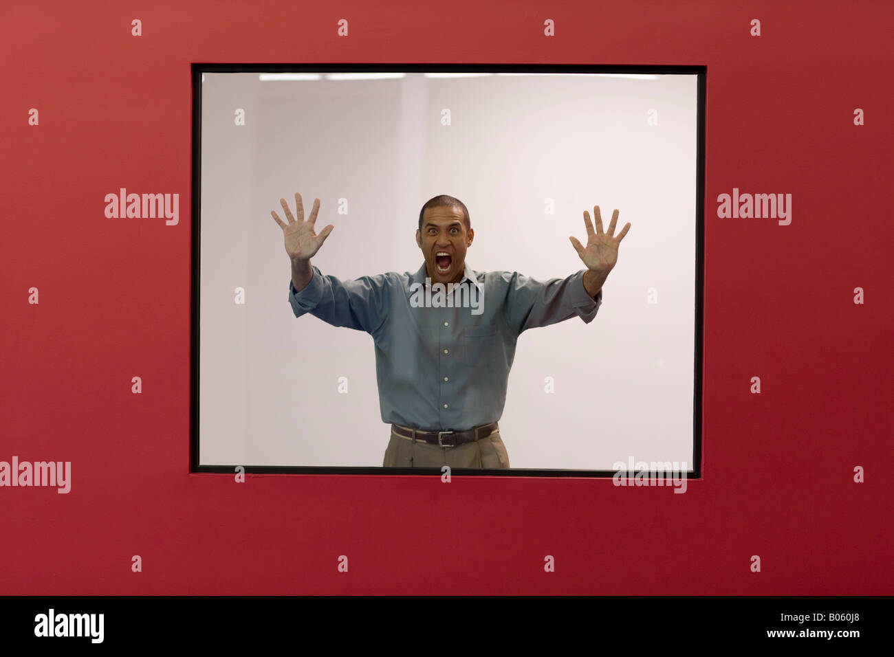 Businessman screaming behind office window Stock Photo - Alamy