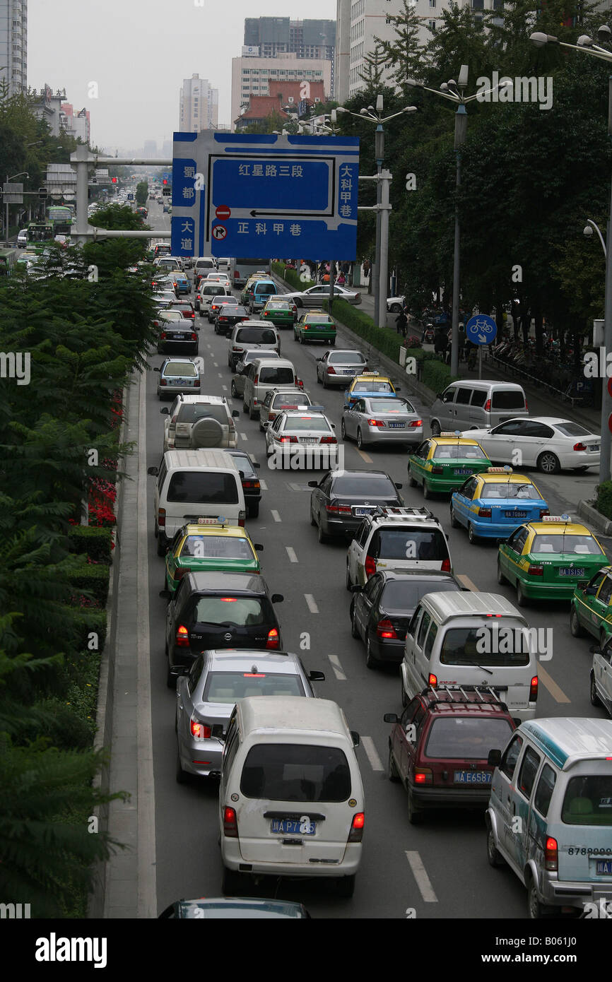 Chinese street scene in the city of Chengdu, China. Traffic moves in ...