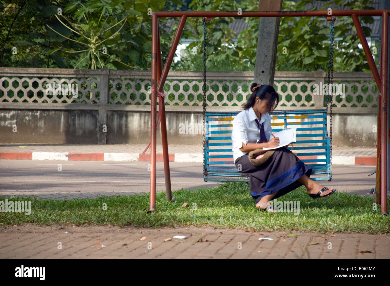 Girl reading a book on a swing Stock Photo - Alamy
