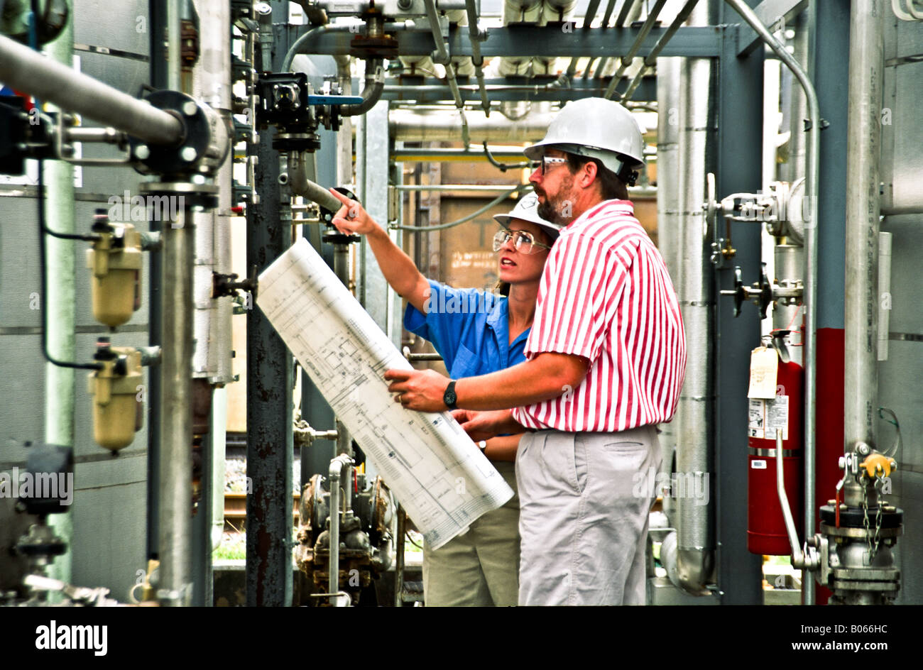Male and female process engineers wearing appropriate safety equipment ...