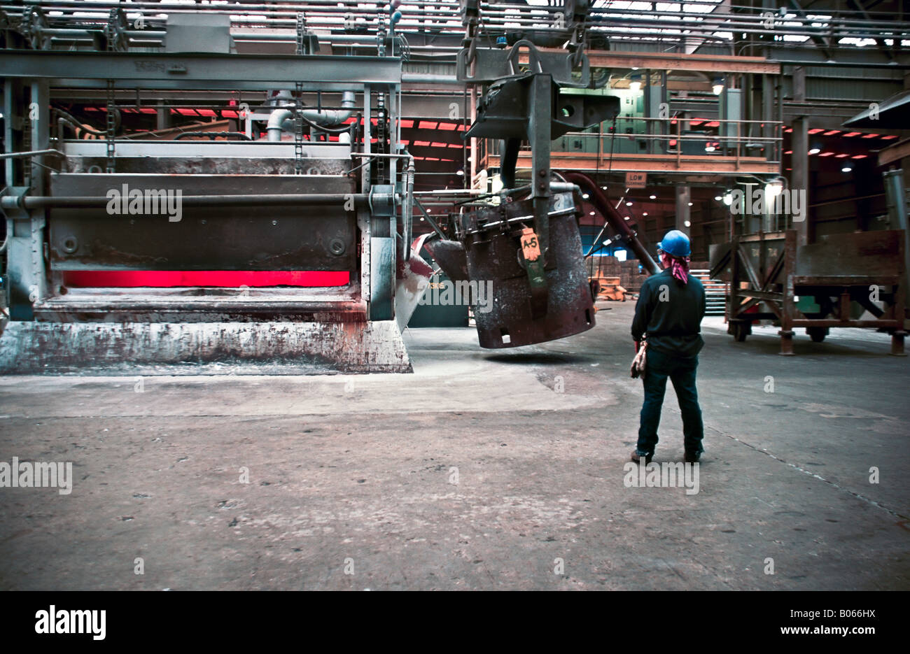 Primary aluminum reduction facility pot line with worker using radio to ...