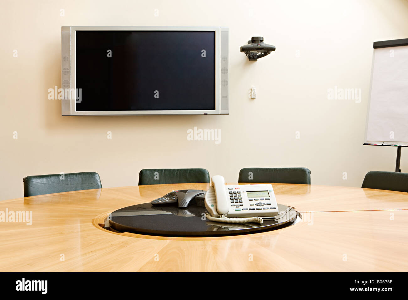 Hall of meetings with a round table the screen on a wall phones and ...