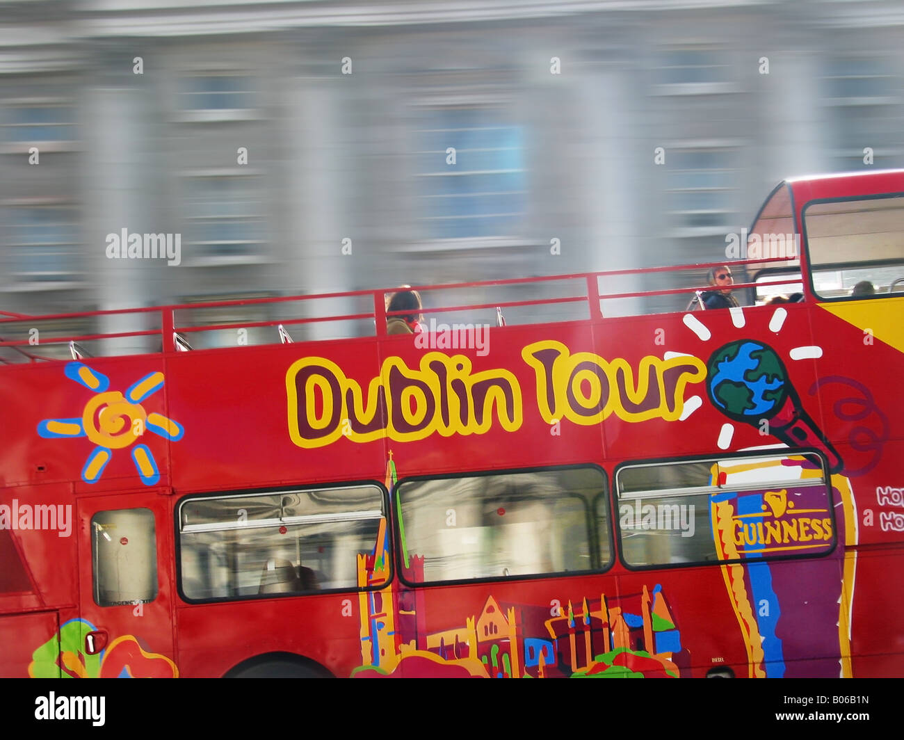 open topped sight seeing bus passing Trinity College in Dublin Ireland ...