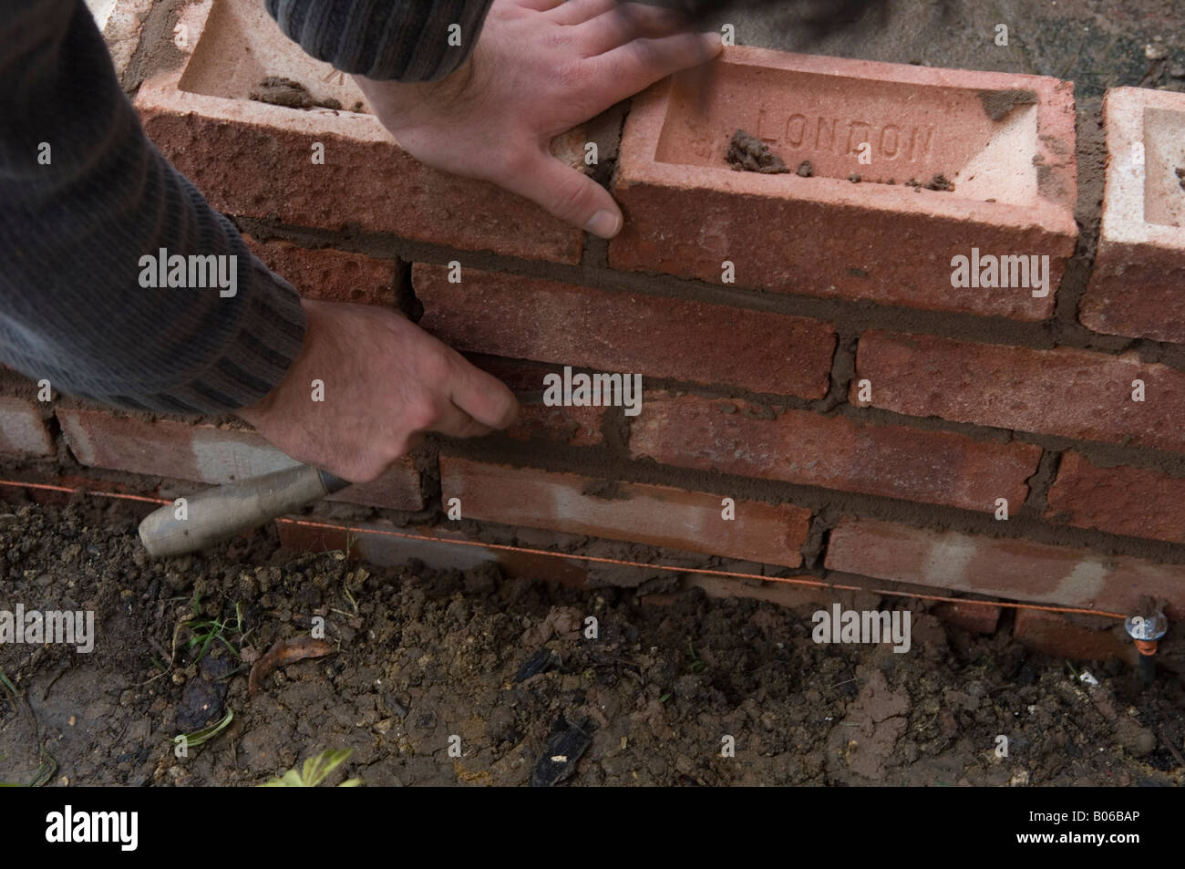 DIY How to build a brick wall Stock Photo - Alamy