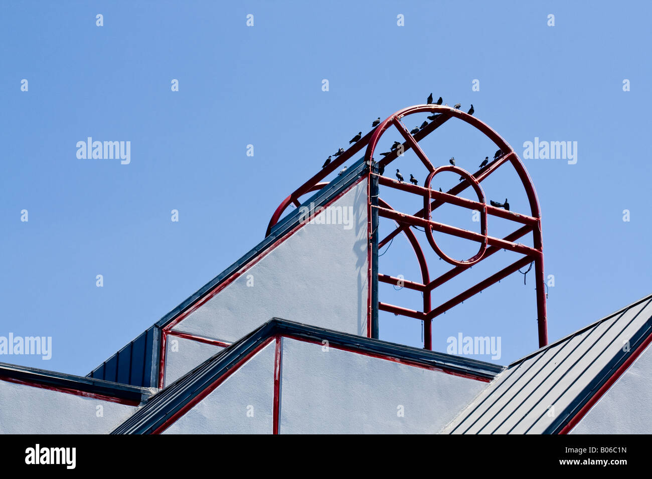 Flock of pigeons sitting on top of a metalk pipe structure on a sunny ...