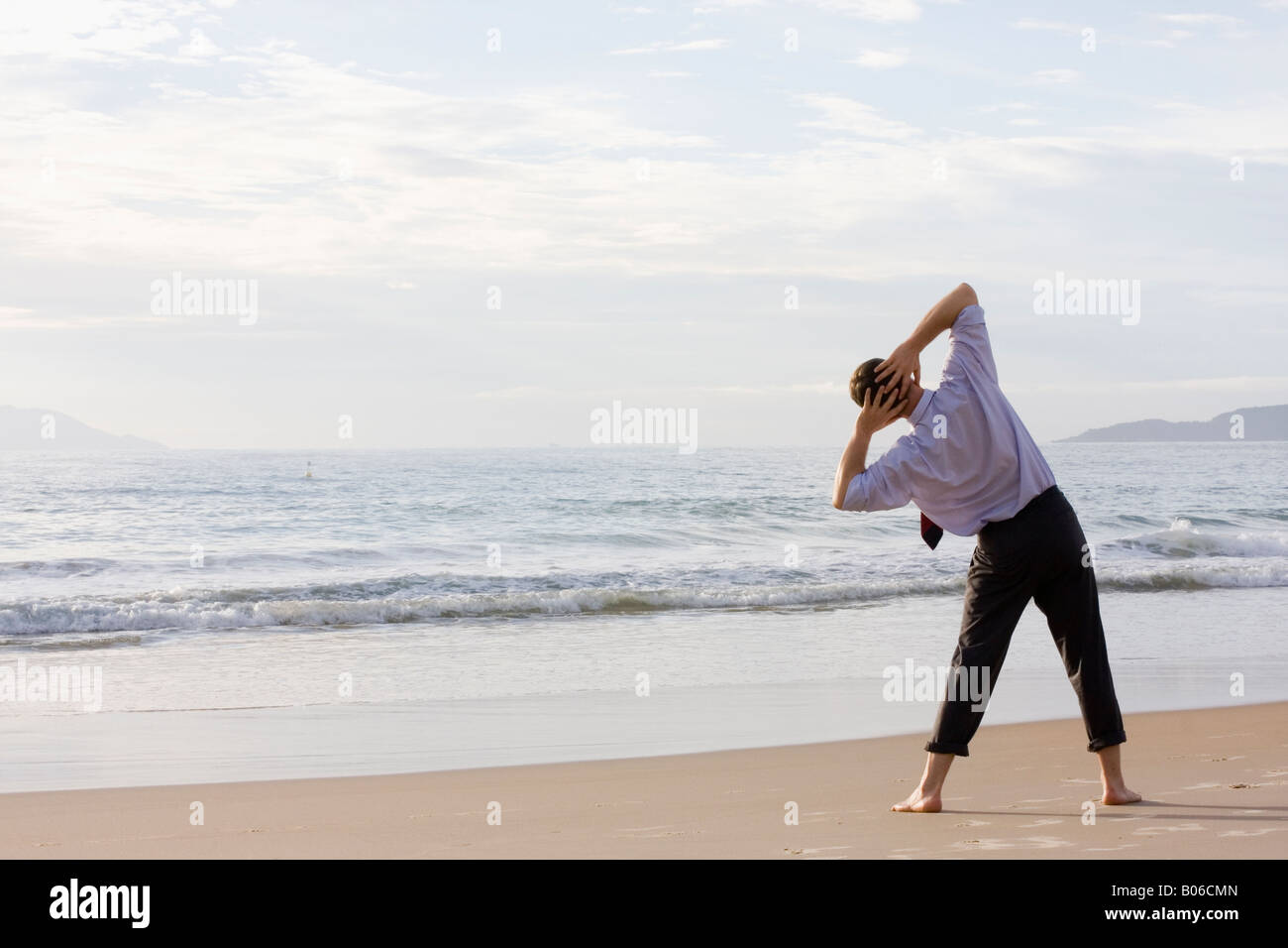 Barefoot businessman doing exercises on a tropical beach Stock Photo ...