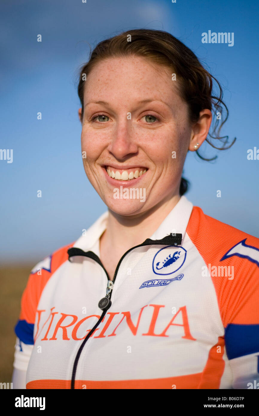 Portrait of a college aged young female cyclist dressed in orange, blue ...