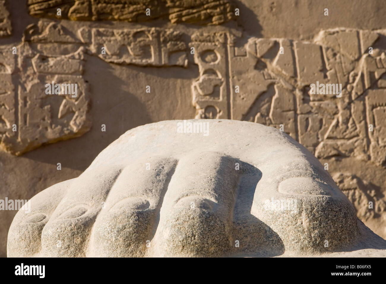 Sculpted colossal foot in front of hieroglyphic reliefs at Luxor Temple ...