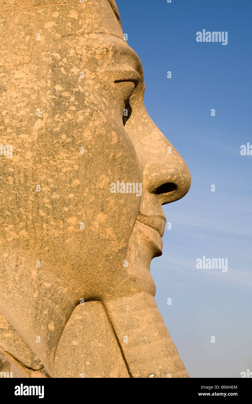 Sculpted colossal head of Ramesses II against blue sky at Luxor Temple ...