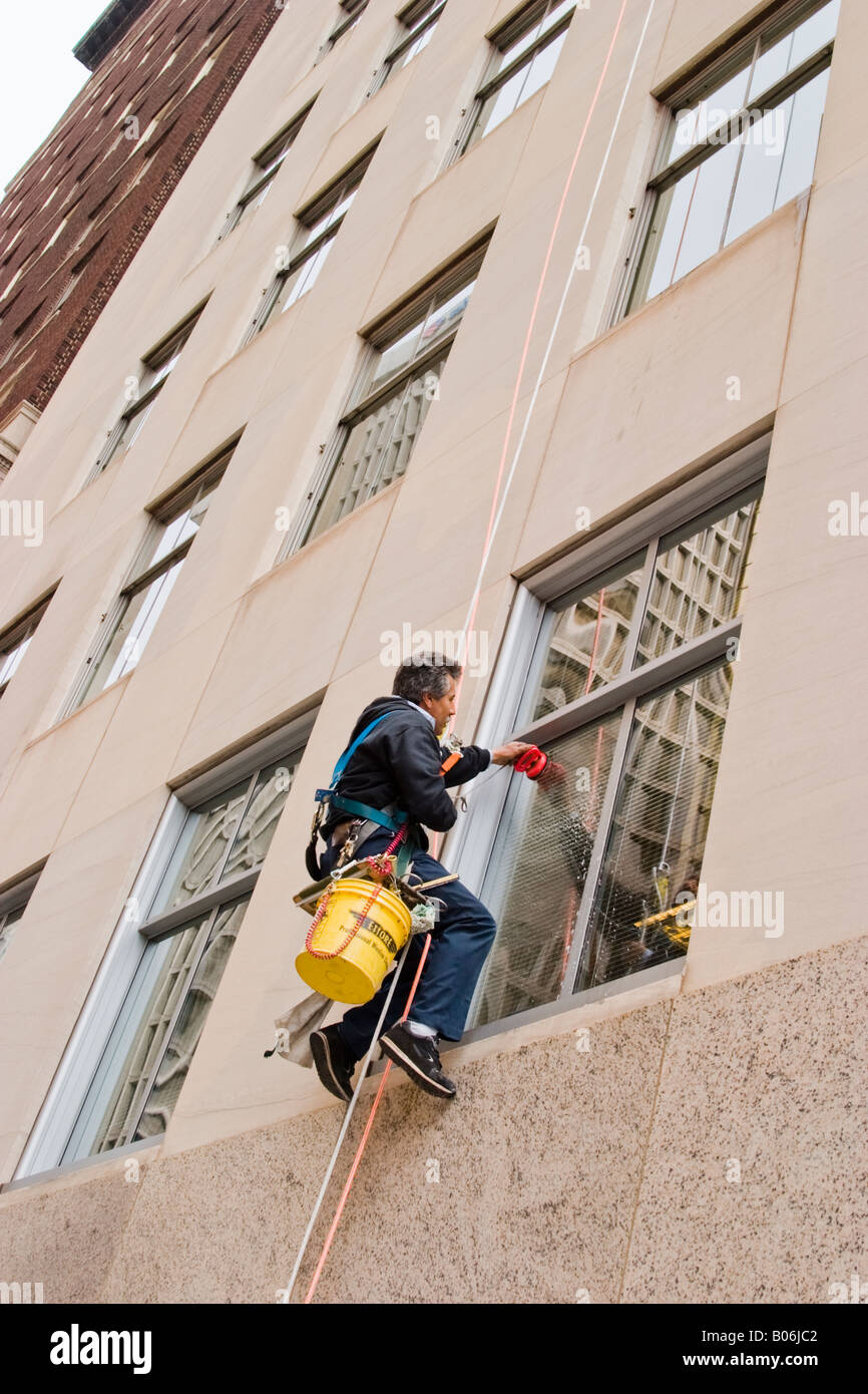 Middle age Hispanic man washing the exterior windows of an office ...