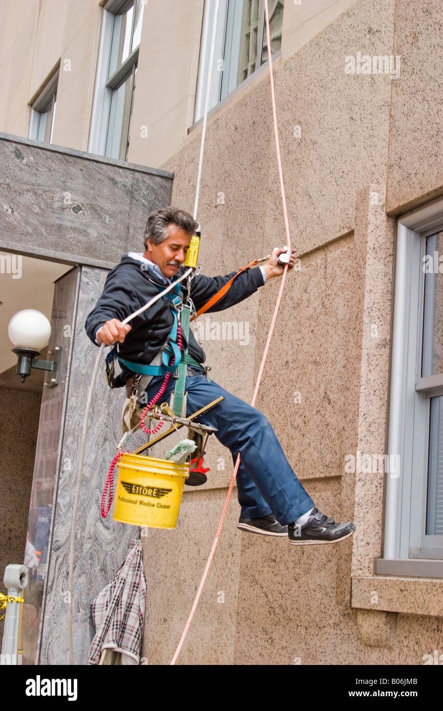 Middle age Hispanic man washing the exterior windows of an office ...