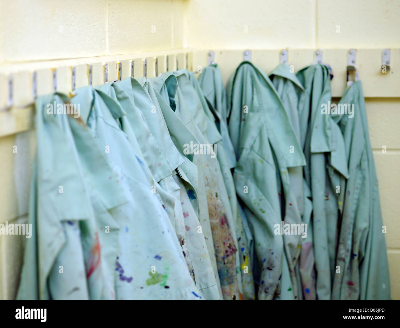dirty coats covered in paint hanging on pegs Stock Photo - Alamy