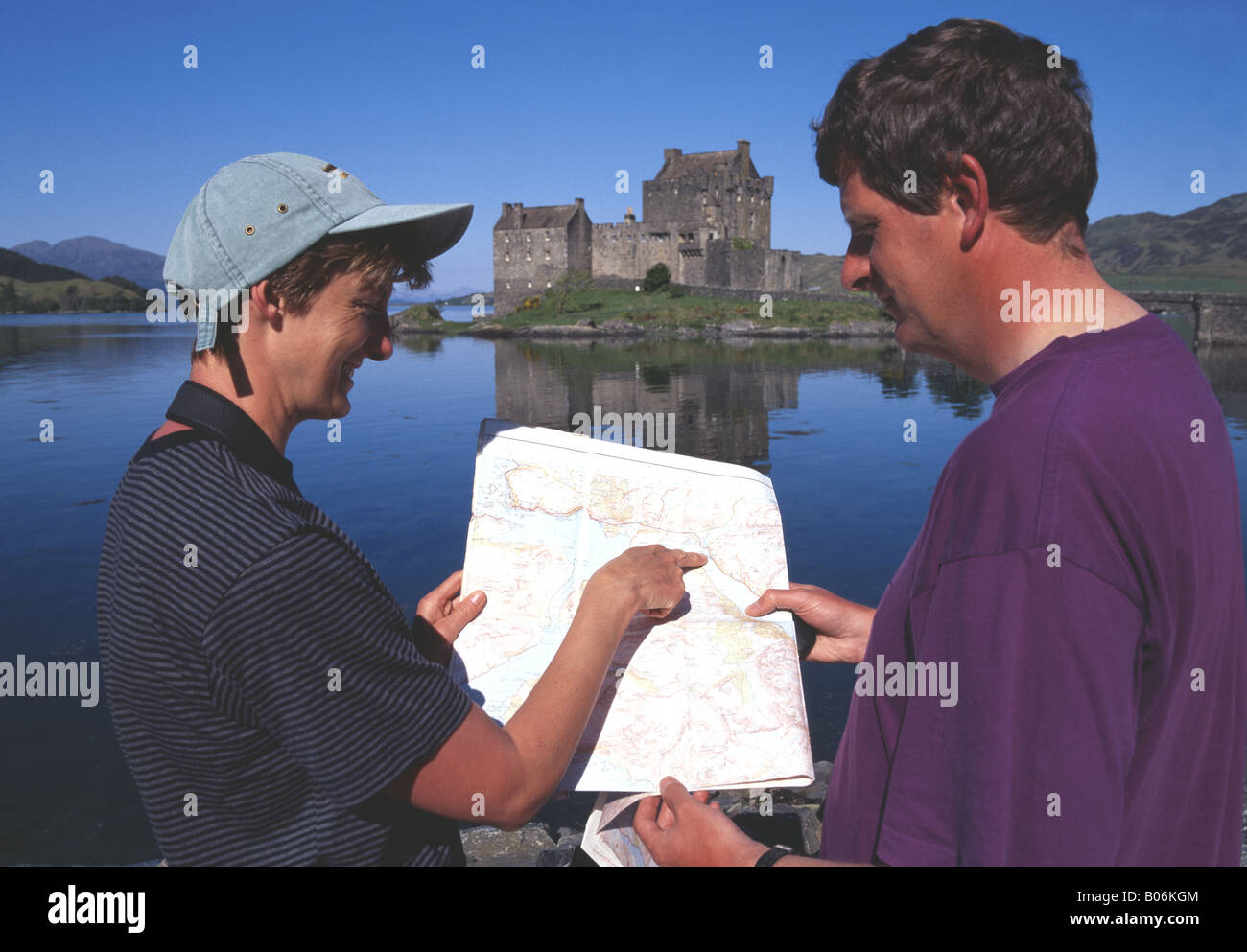 Couple looking at map beside Eilean Donan castle Loch Duich near Kyle ...