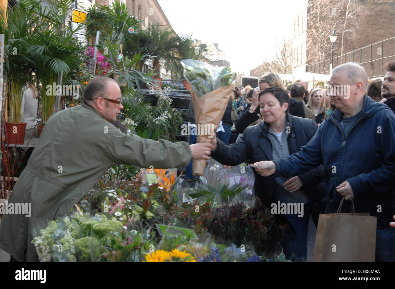 People buying bunch of flowers at Columbia Road Sunday flower market ...