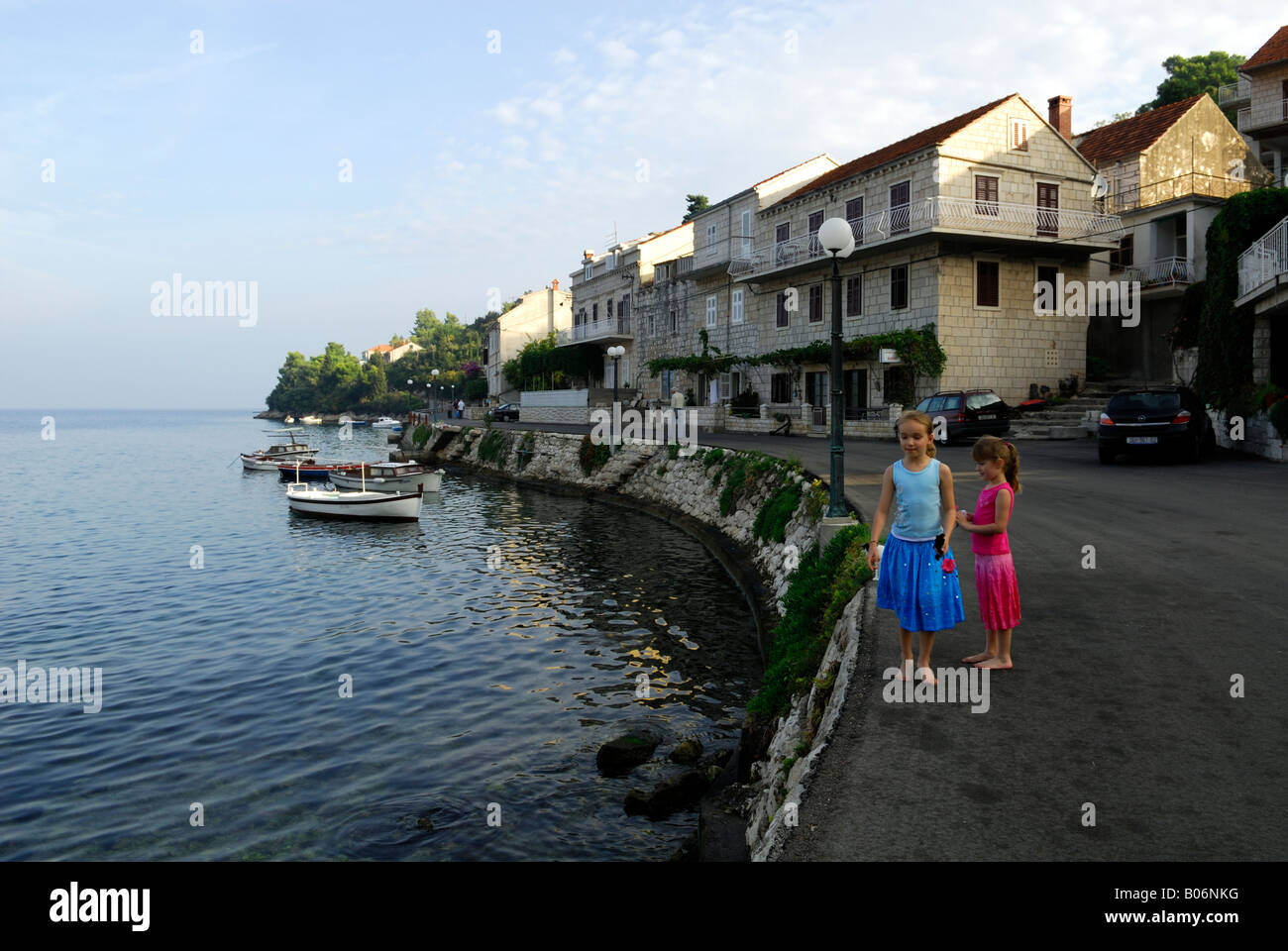 Two children 9 years old and 5 years standing beside harbour. Village ...