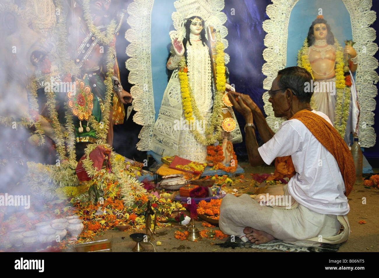 Hindu priest perform elaborate pooja in front of a statue of the Durga ...