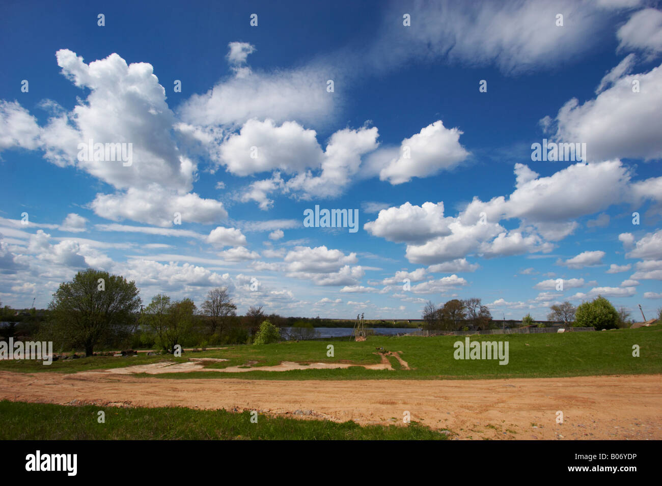 Russian countryside scene with ground village road through field. River ...