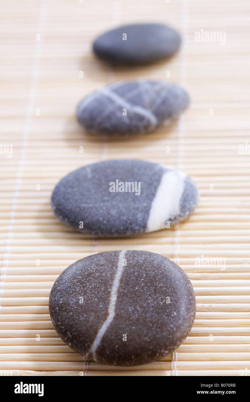 Flat stones for spa massage in a row Stock Photo - Alamy