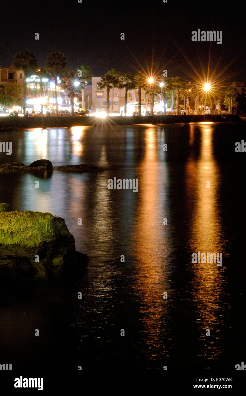 Kato Paphos harbour at night with lights reflected in the still water ...