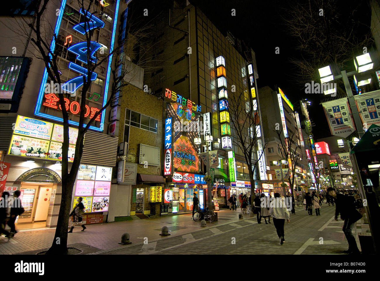 Pedestrians in the street. Neon lit night scene, Shinjuku, Tokyo, Japan ...