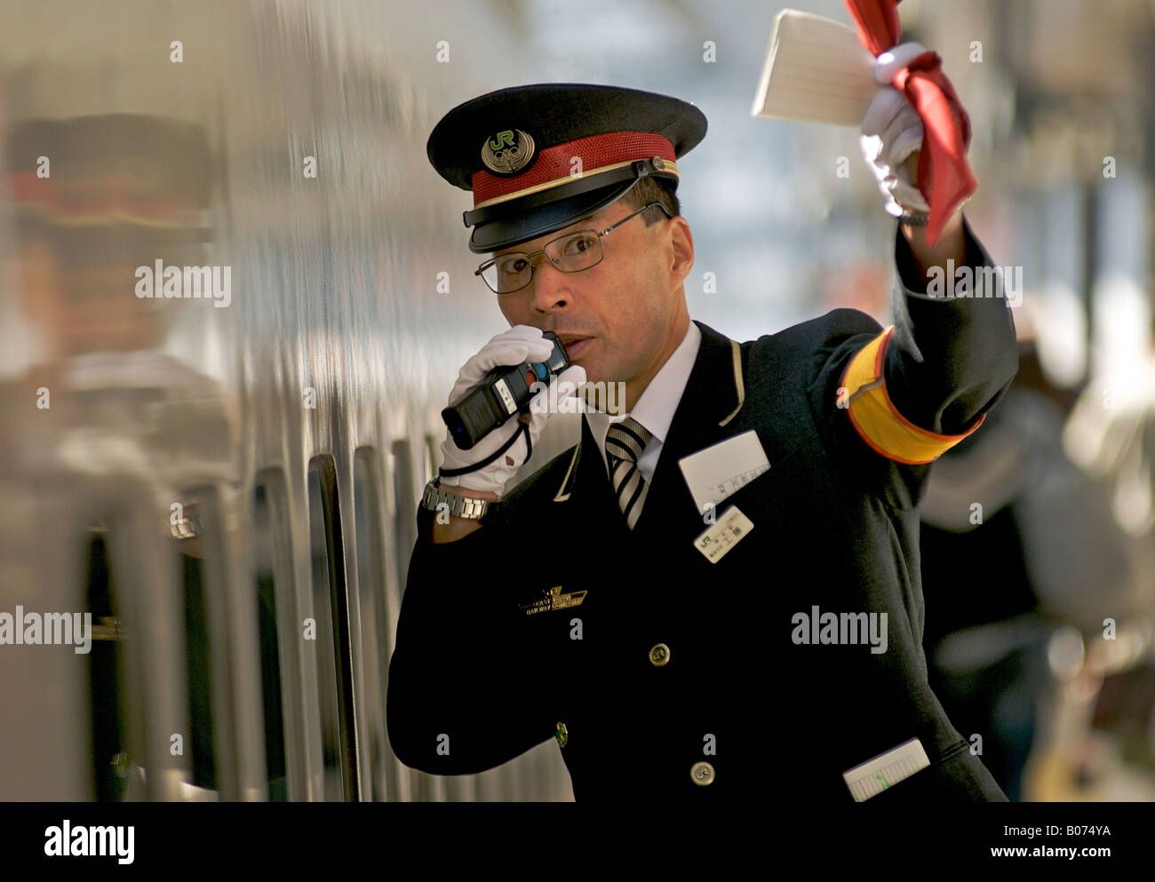 Platform guard signalling for the departure of a Shinkansen 'Bullet ...