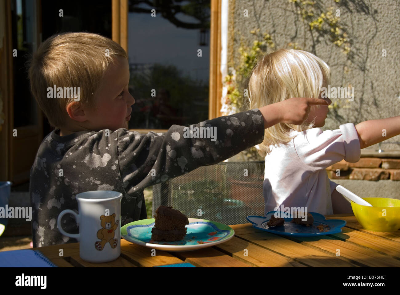 Stock photo of a young brother and sister sitting at a table and ...