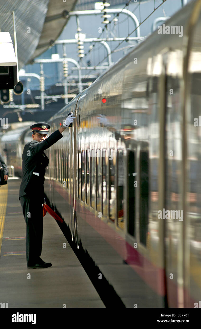 Platform guard signalling for the departure of a Shinkansen 'Bullet ...