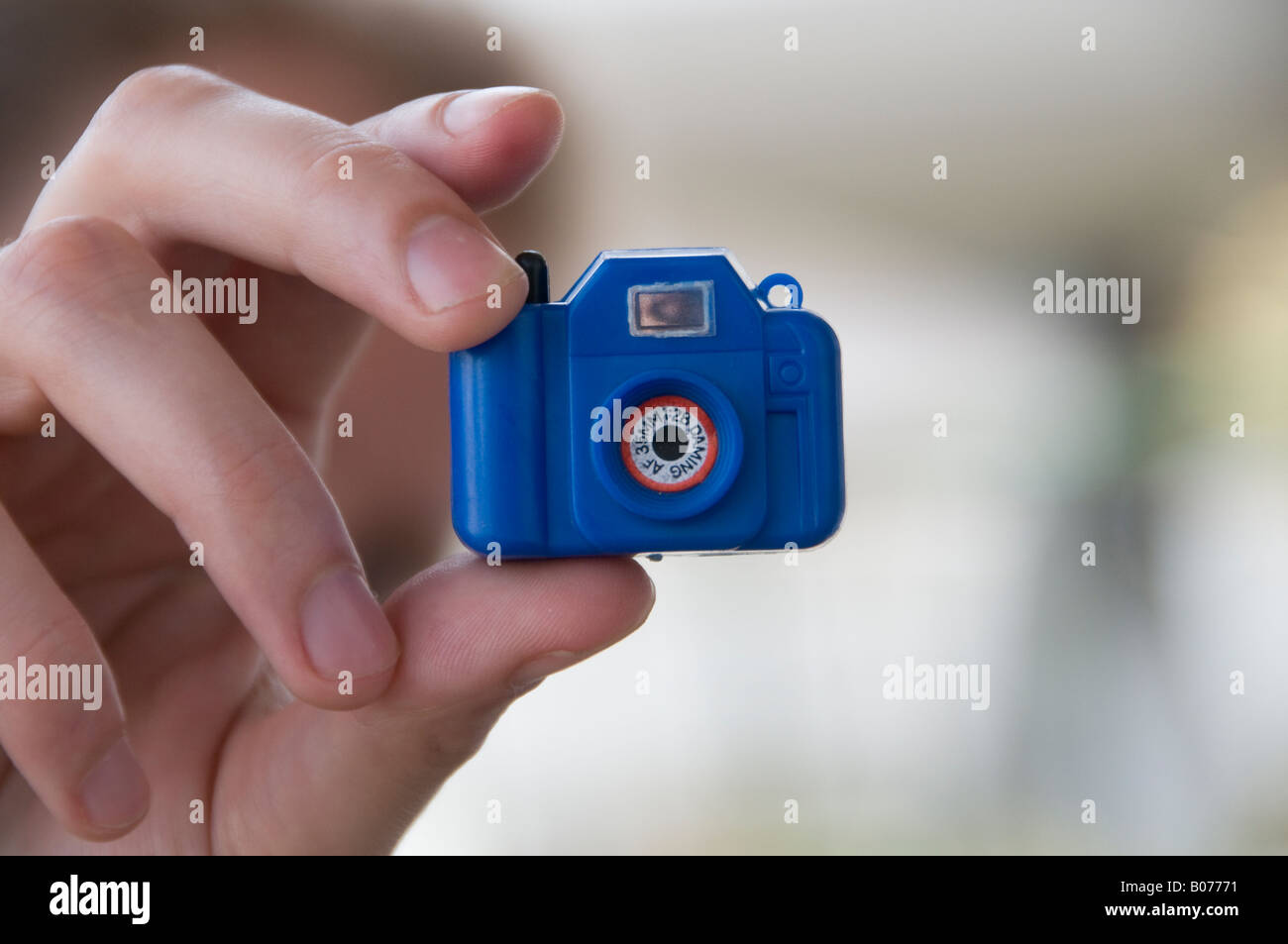 Young man holding a small toy camera Stock Photo - Alamy