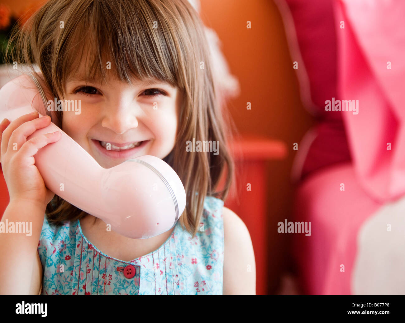 Happy young girl playing with a big pink phone Stock Photo - Alamy