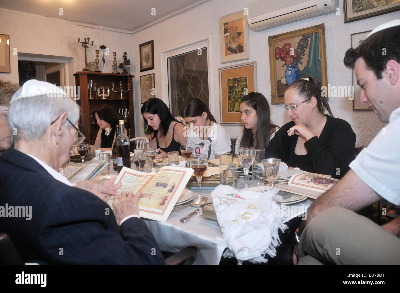 family sitting around a table set for a Jewish Festive meal on Passover ...