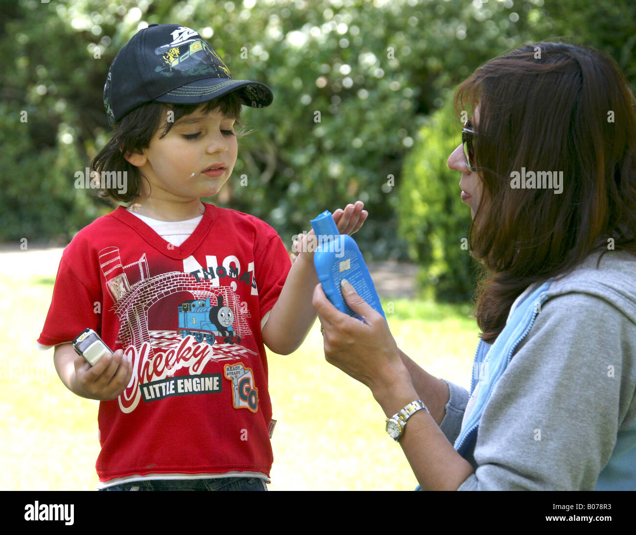 Mother applying sunscreen to smiling boy’s arm Stock Photo - Alamy