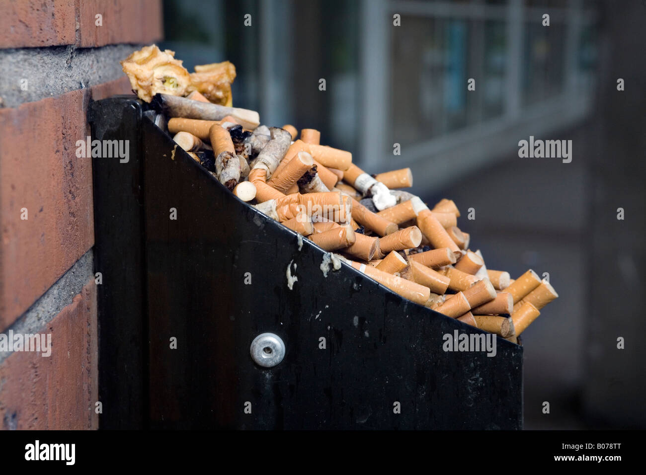 Detail view of an overfilled ashtray outside a public building The ...