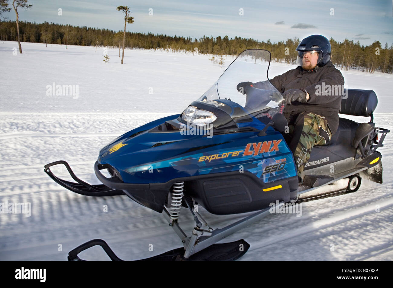 A men in protective sportswear riding snowmobile Snowmobile is an ...