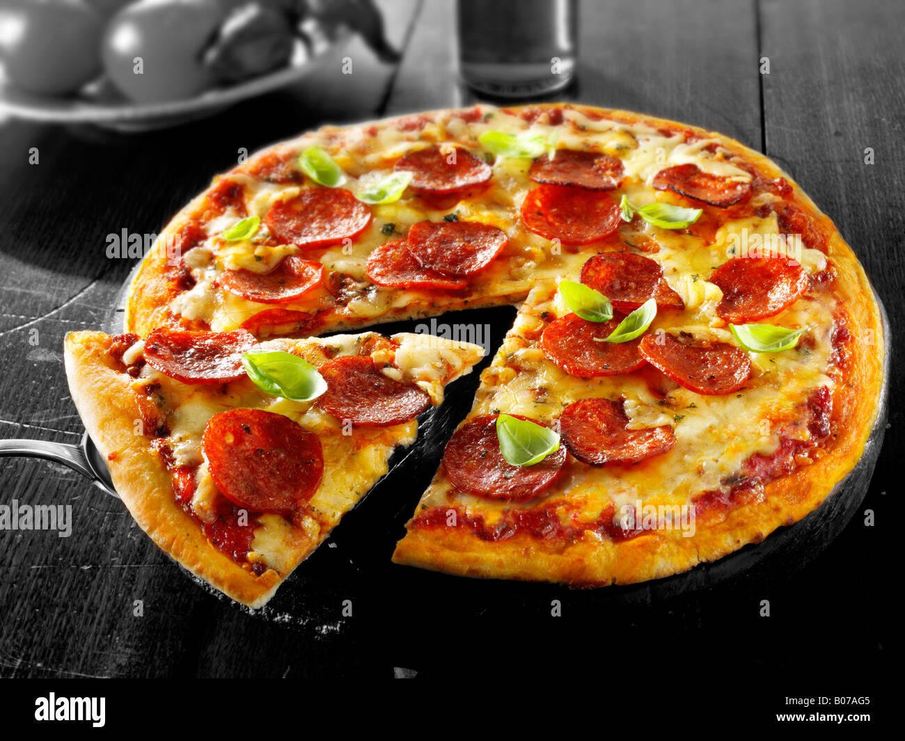 Rain crust pepperoni pizza with a slice out Stock Photo - Alamy