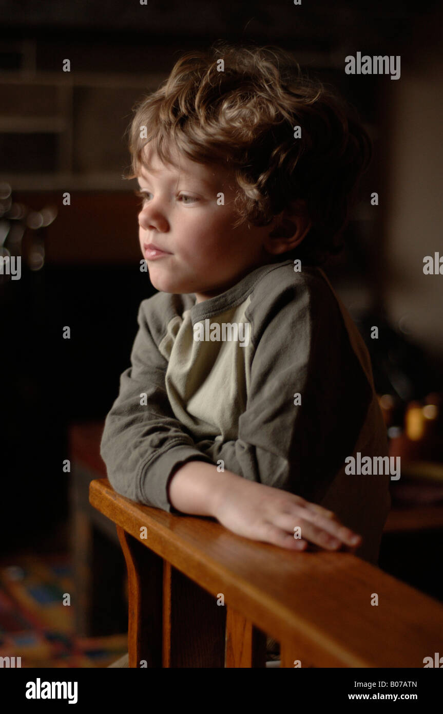 A young boy sitting alone Stock Photo - Alamy