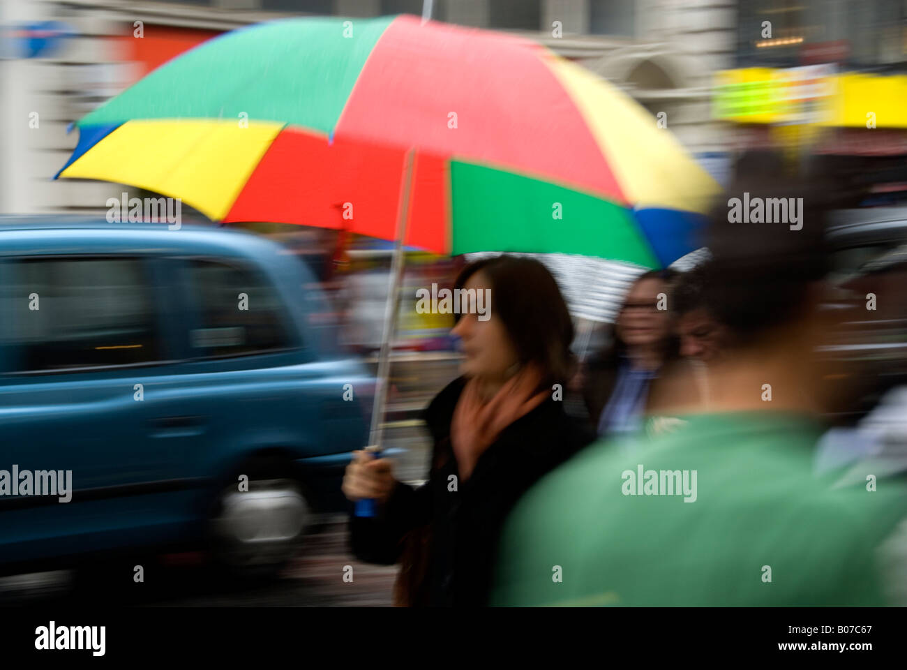 Motion blur - woman hurrying along the street with a colourful ...
