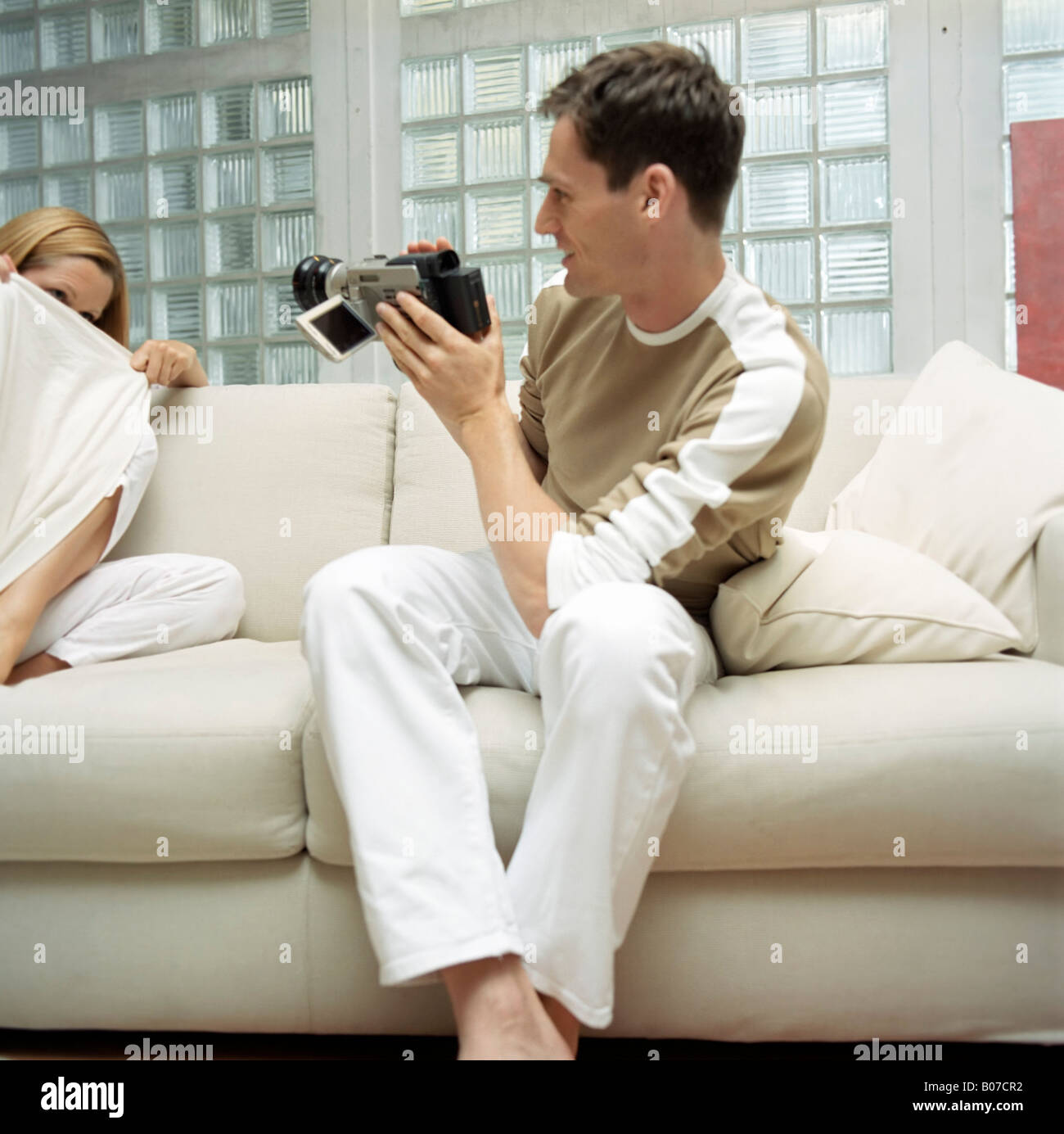 Man filming a blond woman on the settee - Couple - Hobby - Living Room ...