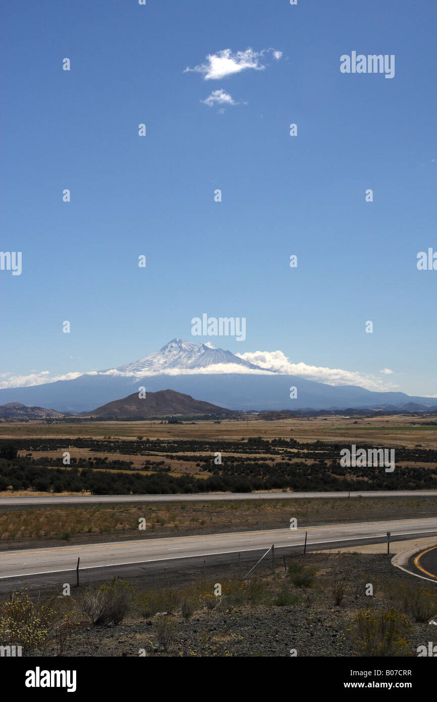 A view of Mount Shasta in California, USA, below a small white cloud ...