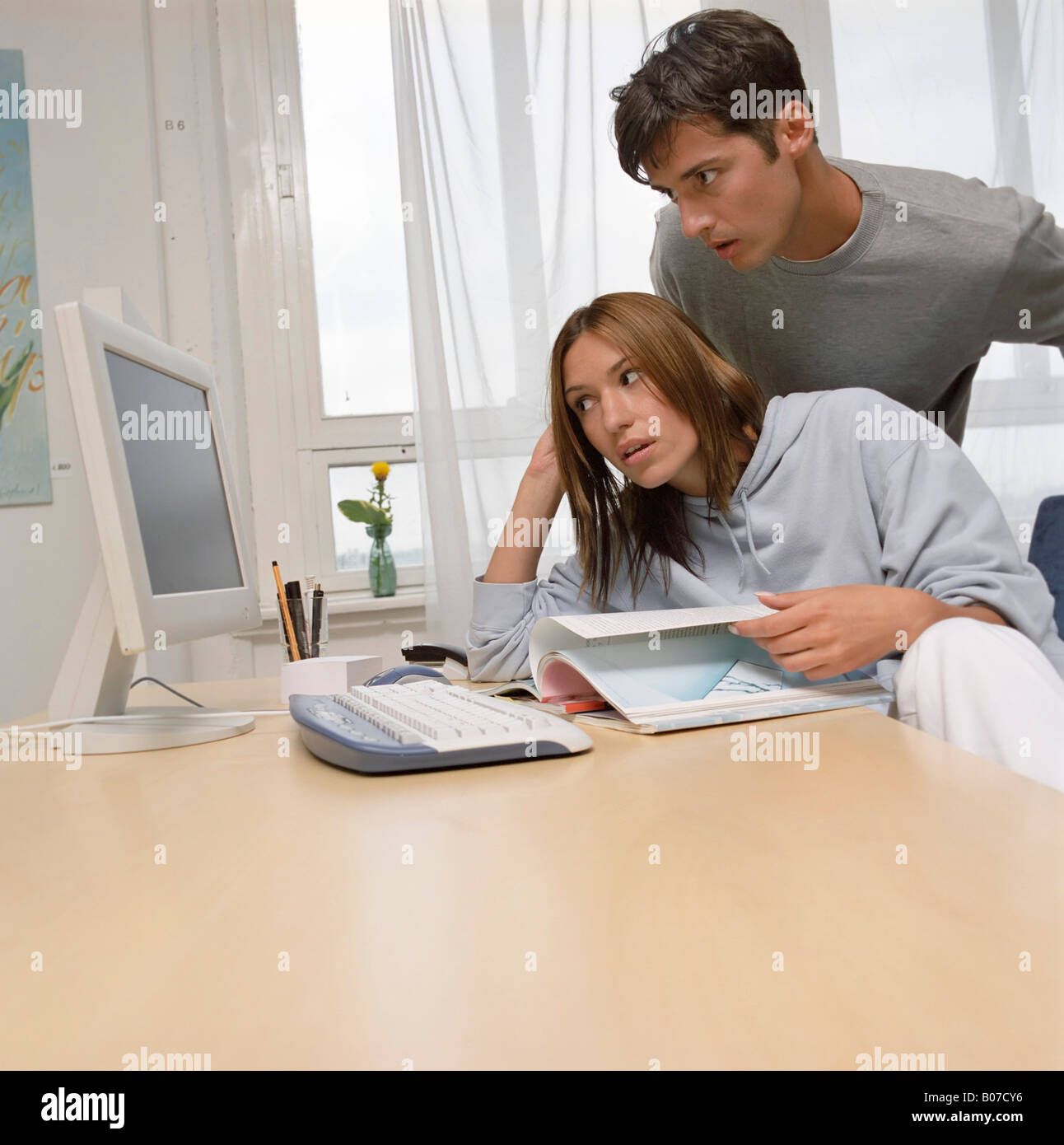Young couple in front of a computer Stock Photo - Alamy
